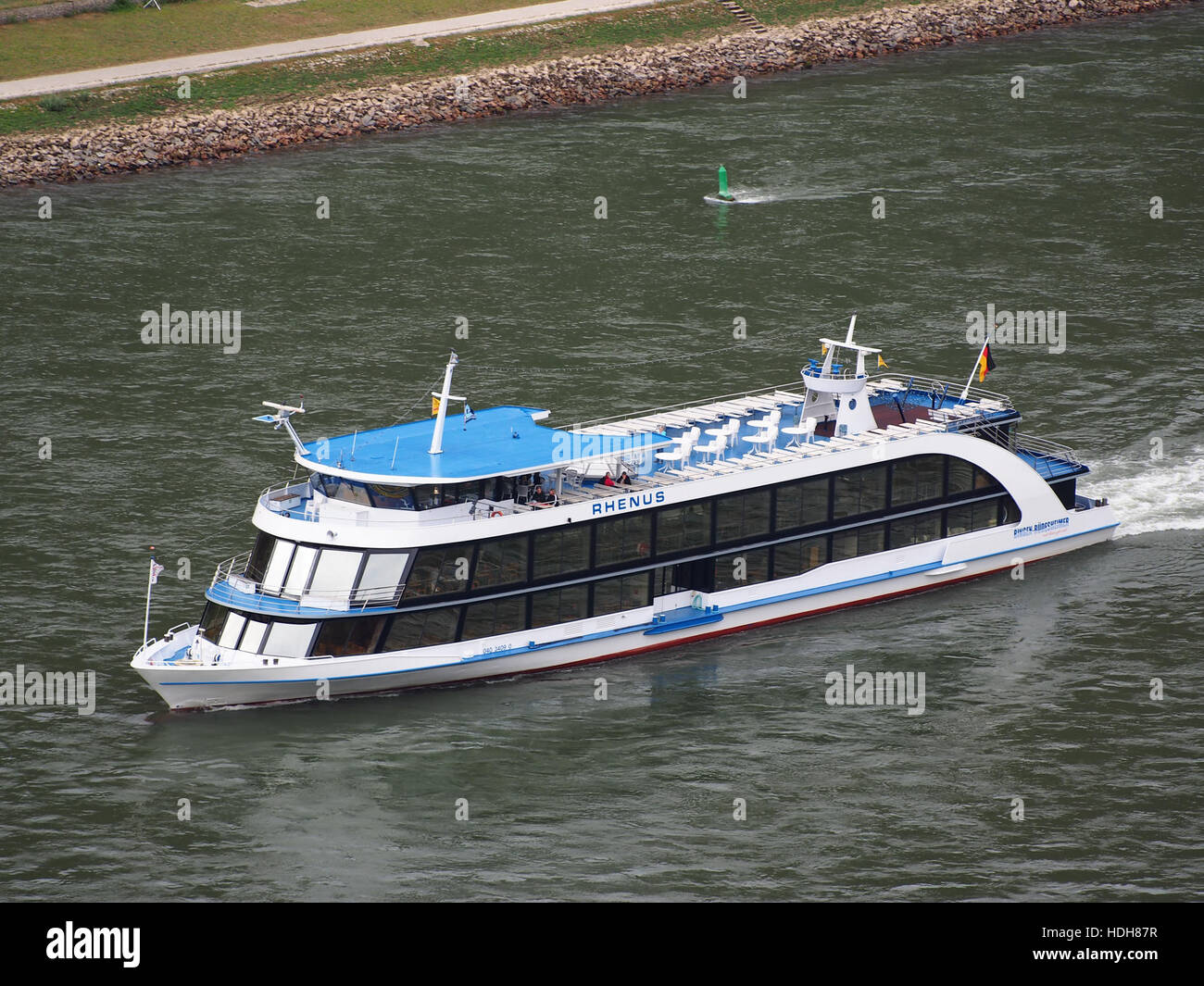 The Rhenus, a cargo ship, is depicted navigating the Rhine River near ...