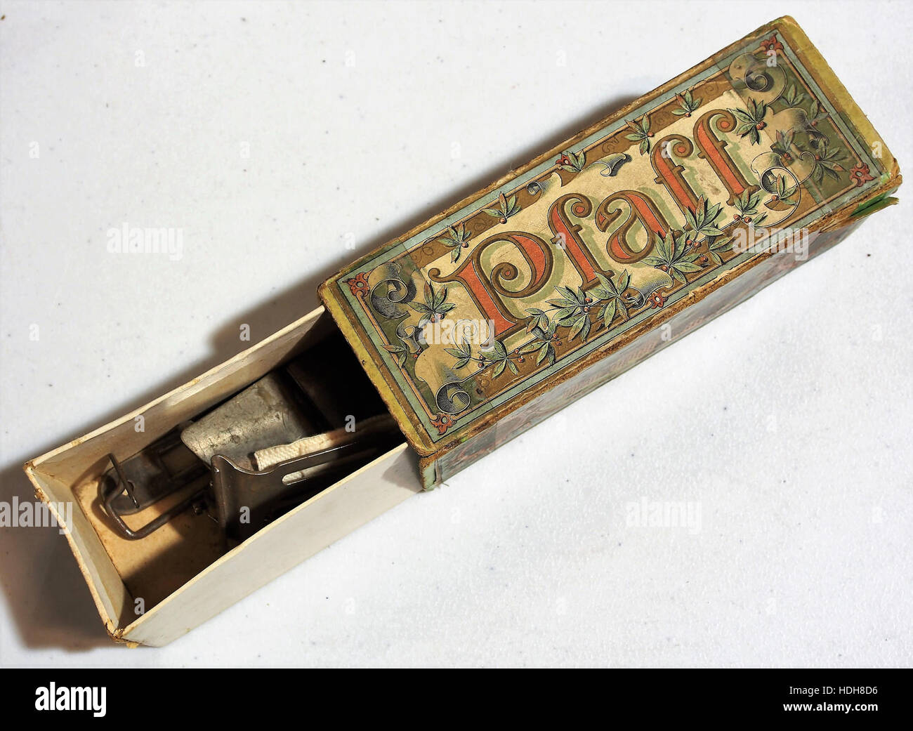 This image depicts an old tin storage box, likely used for biscuits or ...