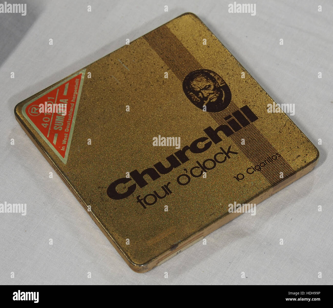 This image depicts a tin can of Churchill cigarillos, reflecting the ...