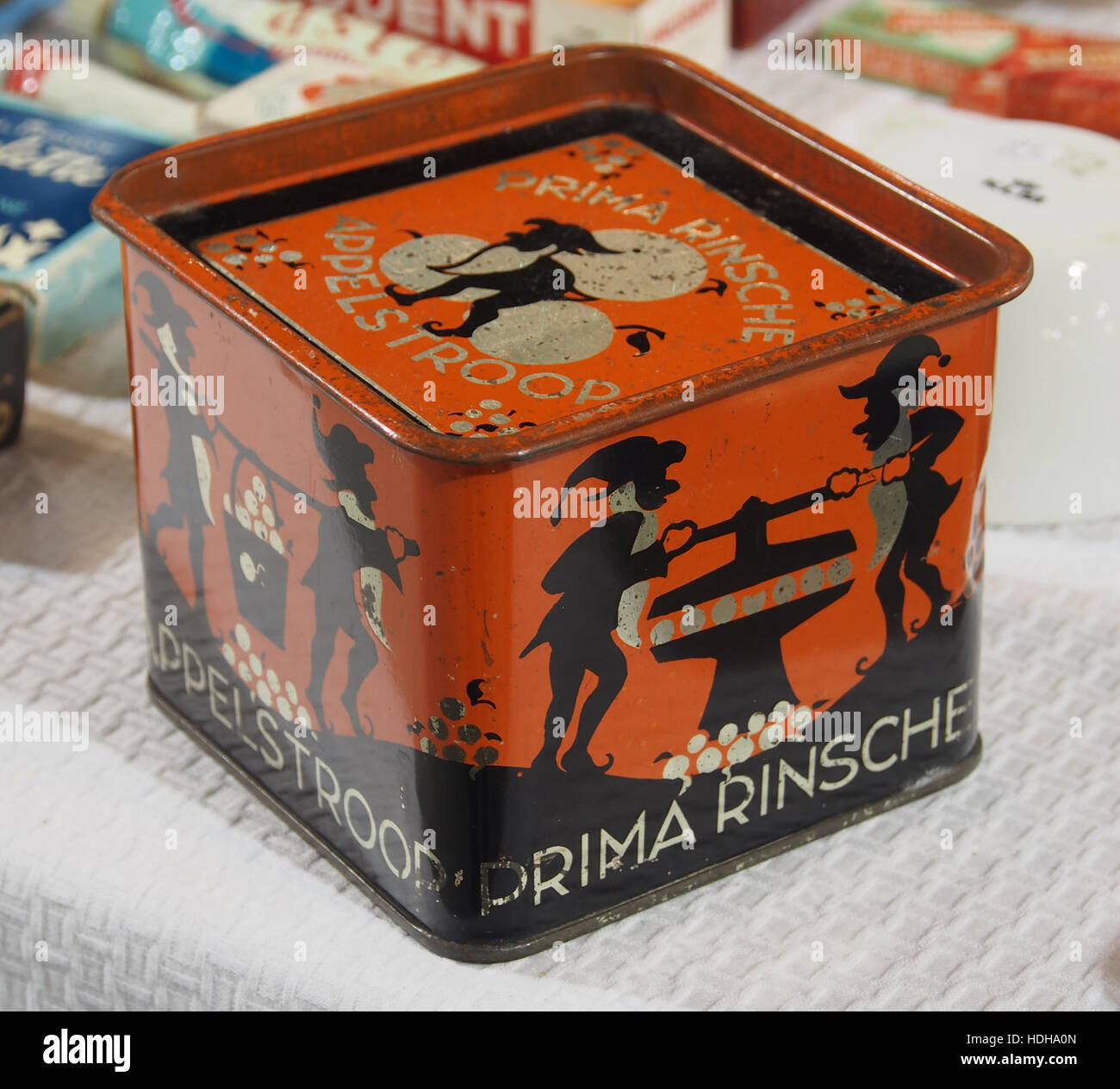 This image shows a square tin can of Prima Rinsche Appelstroop, a ...