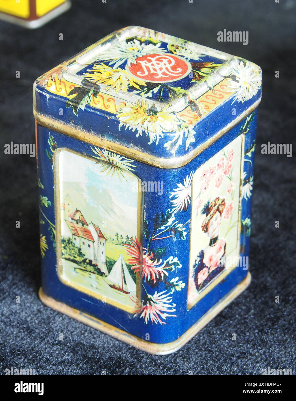 This image showcases a blue tea tin, likely vintage, with intricate ...
