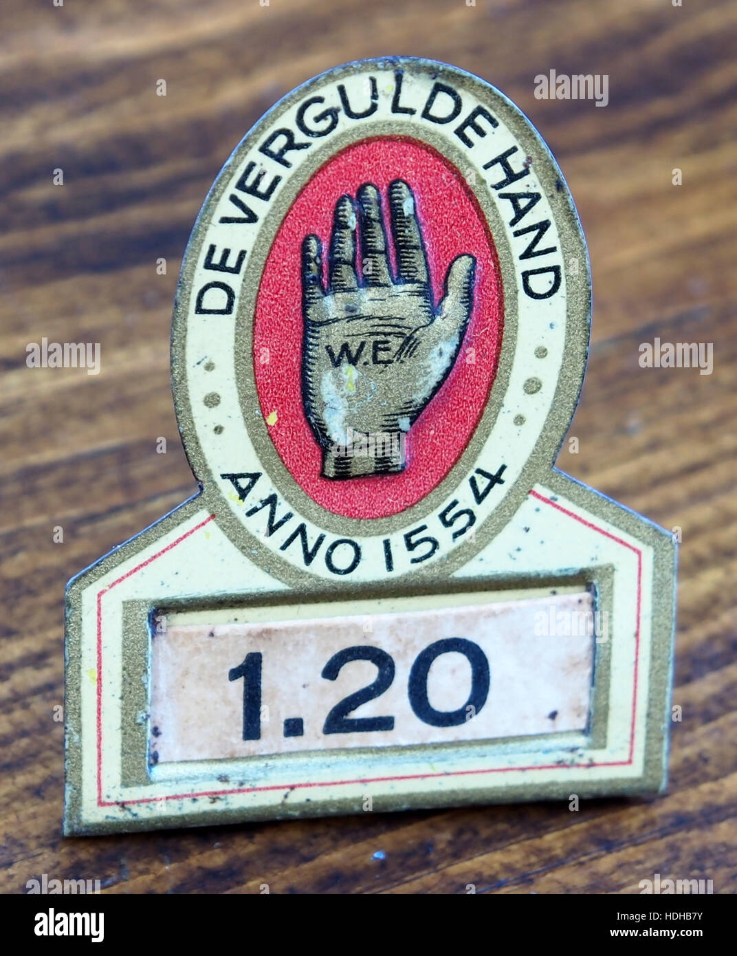 This image shows a metal price sign from *De Vergulde Hand*, a ...
