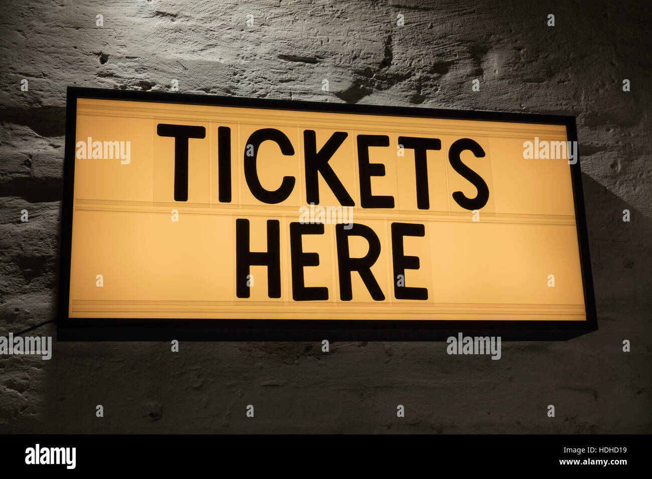 Close-up of Tickets Here signboard against gray wall Stock Photo - Alamy