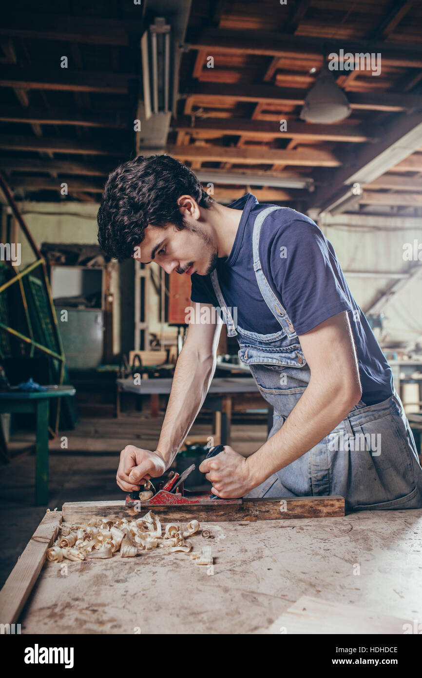 Carpenter planing timber at workshop Stock Photo - Alamy