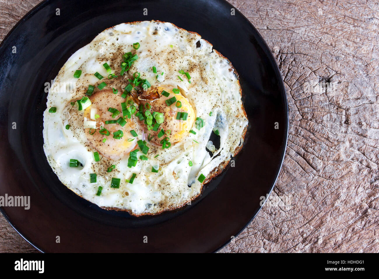 Fried eggs with double yolks sprinkle with pepper and Spring onion ...