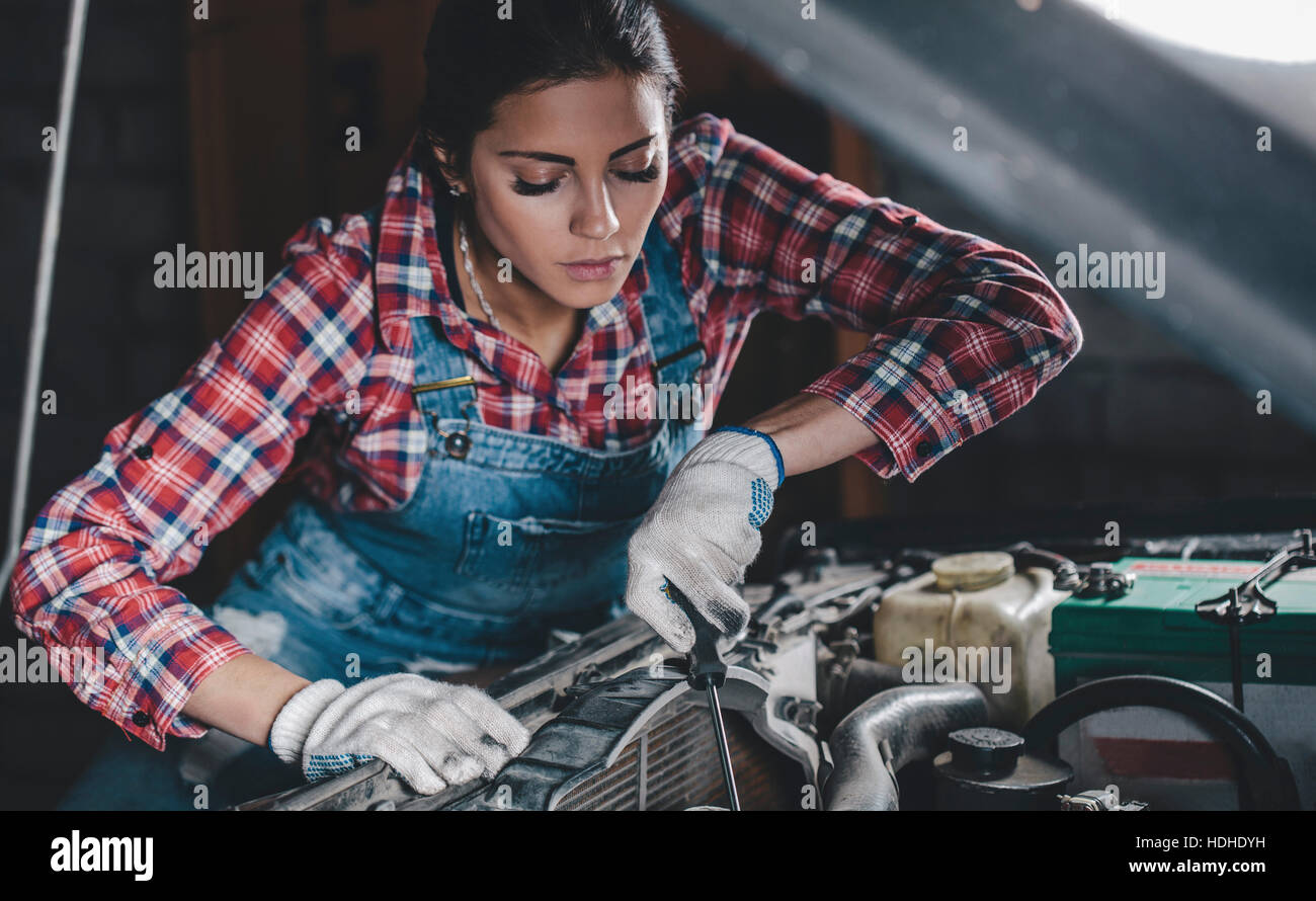 Female mechanic repairing car engine at workshop Stock Photo - Alamy