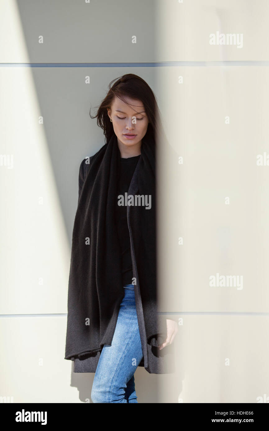 Woman standing by wall hi-res stock photography and images - Alamy