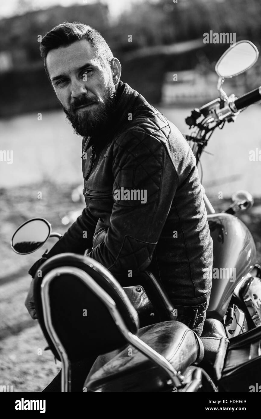 Side view of man sitting on motorcycle at lakeshore Stock Photo - Alamy