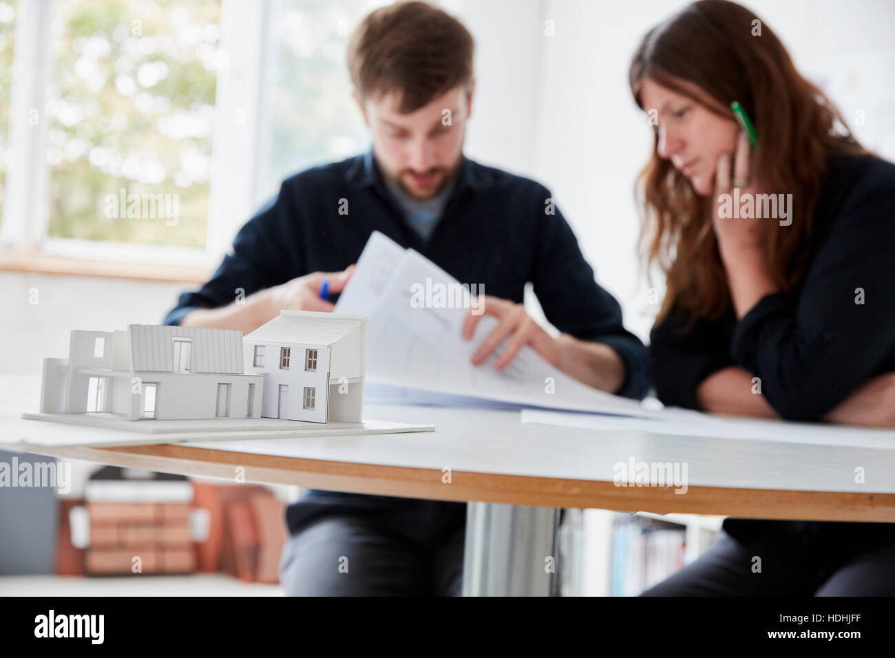 A modern office. Two people at a meeting discussing plans and ...