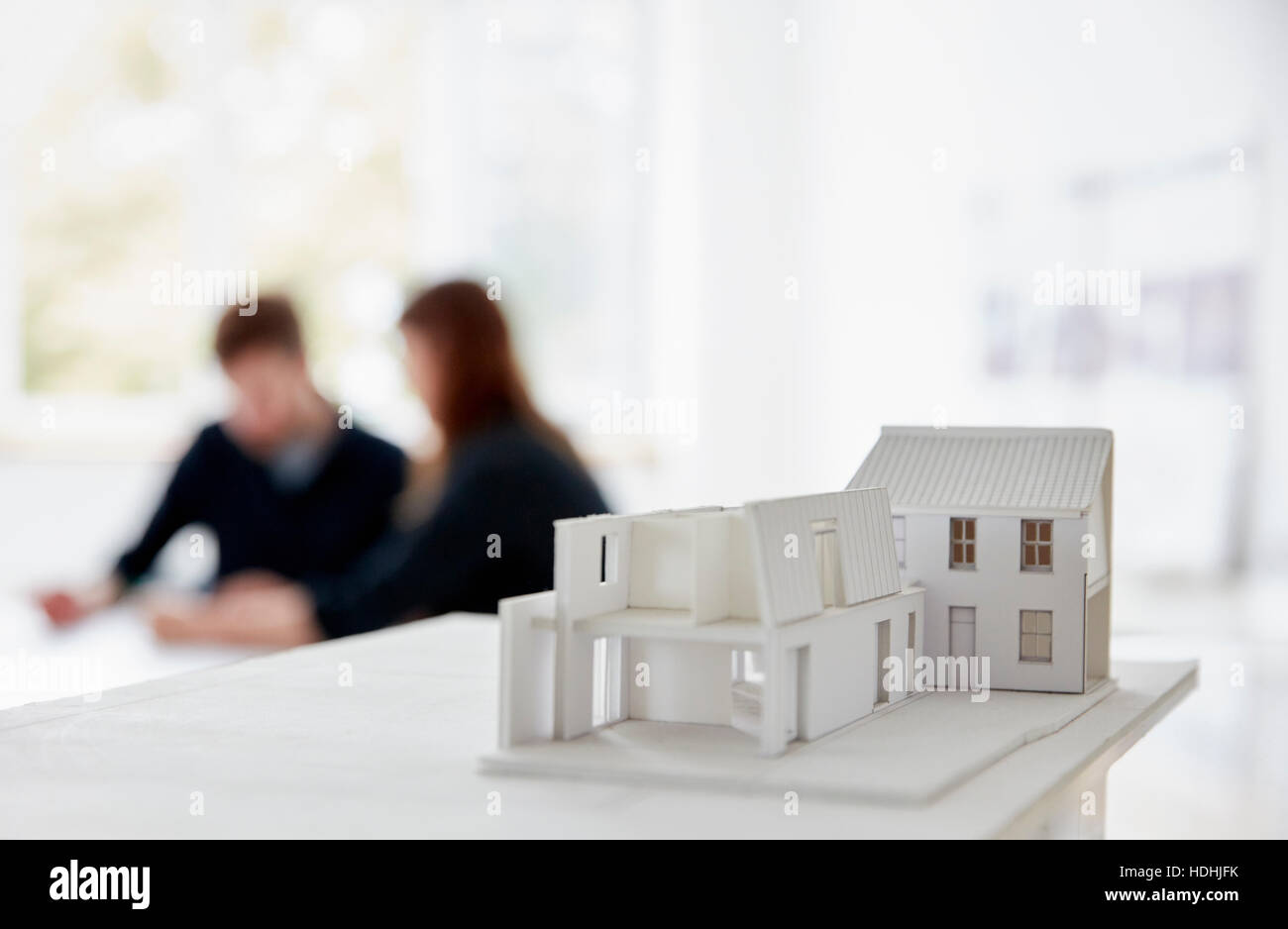 Architect's model of a building with two people at a meeting out of ...