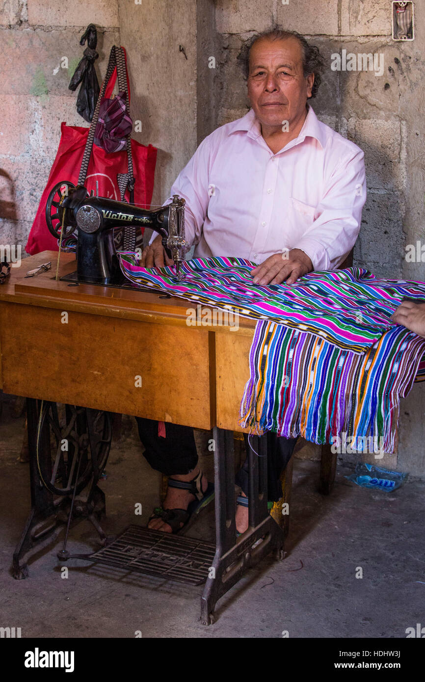 A middle-age male tailor sewing on a foot-treadle sewing machine in San ...