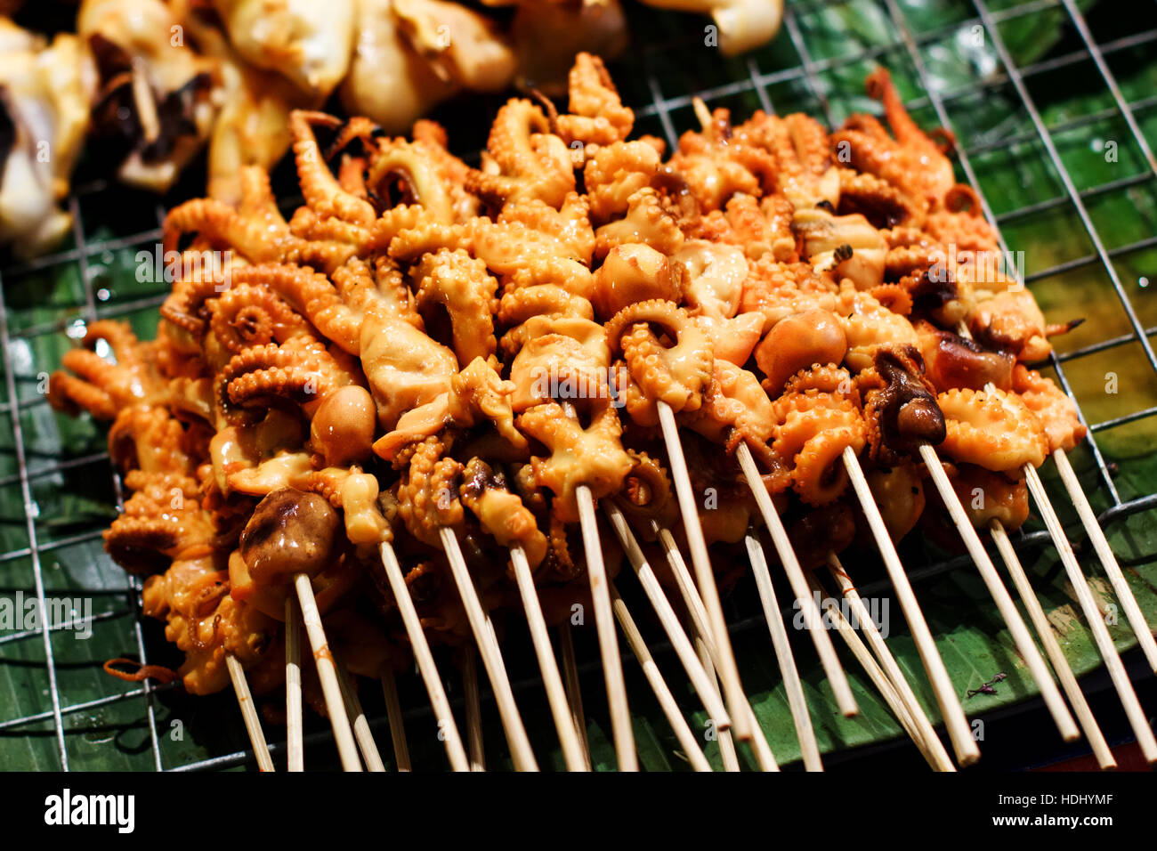 Street food in Asian country, roasted small octopuses on stick Stock ...