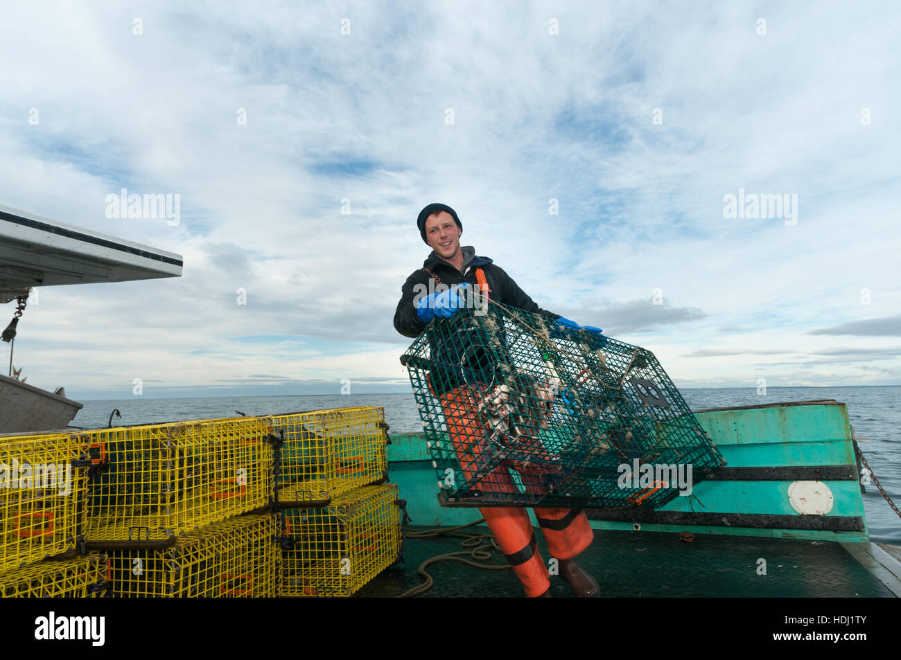 Sternman on lobster boat stacks traps, Yarmouth Stock Photo - Alamy