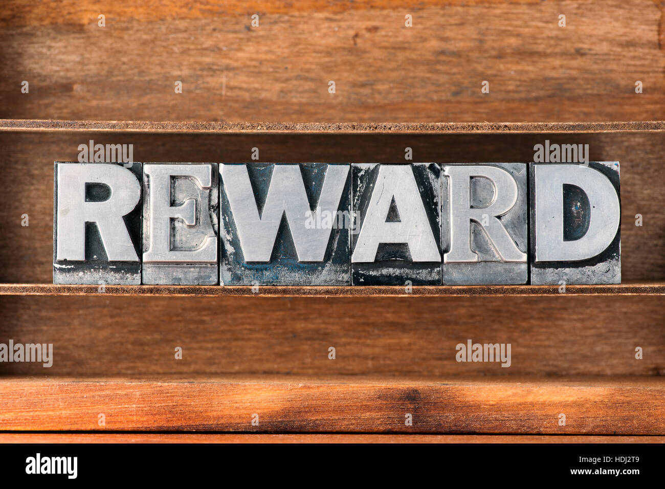 reward word made from metallic letterpress type on wooden tray Stock ...