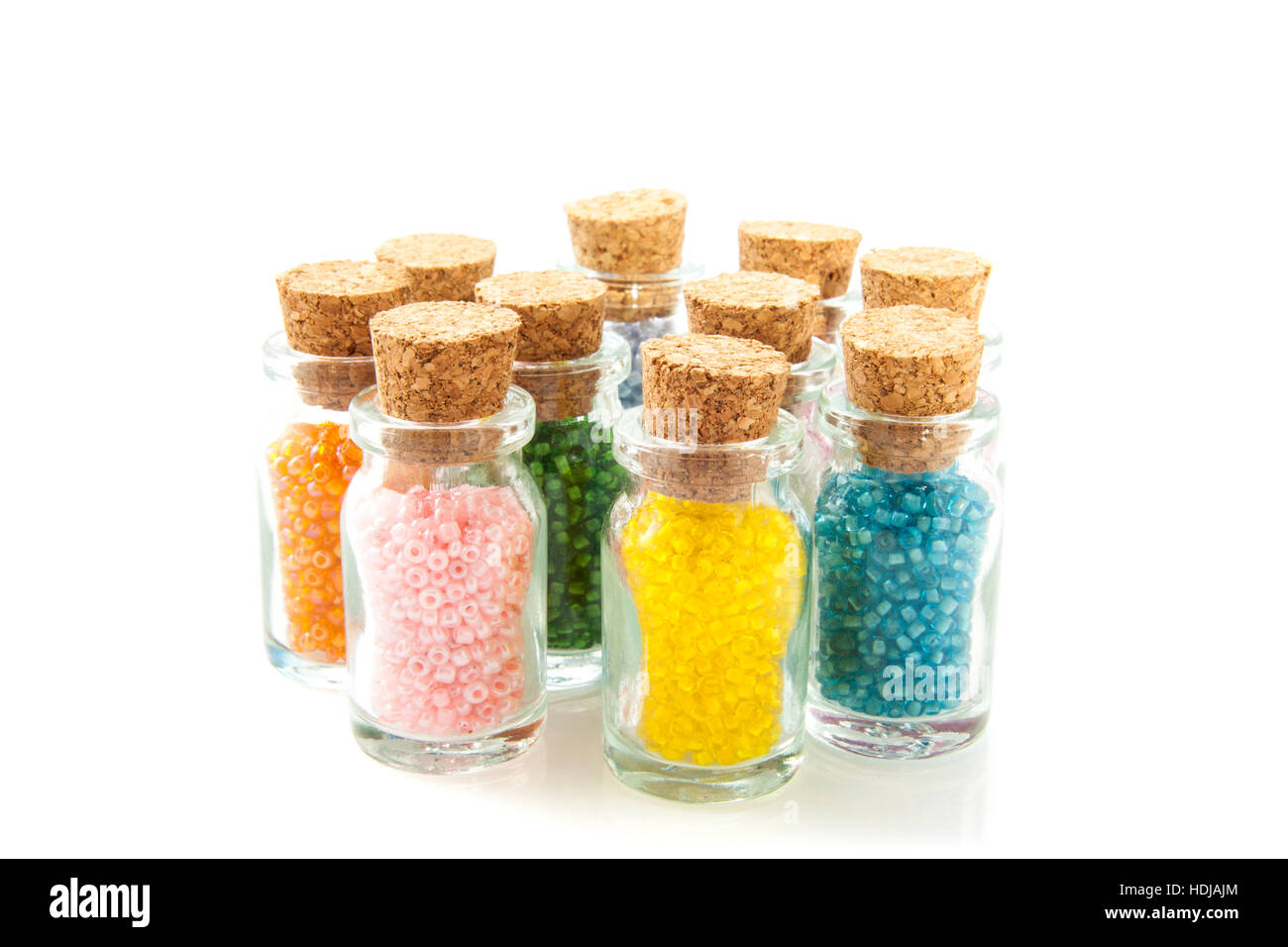 Little bottles filled with little beads in a row isolated over white ...