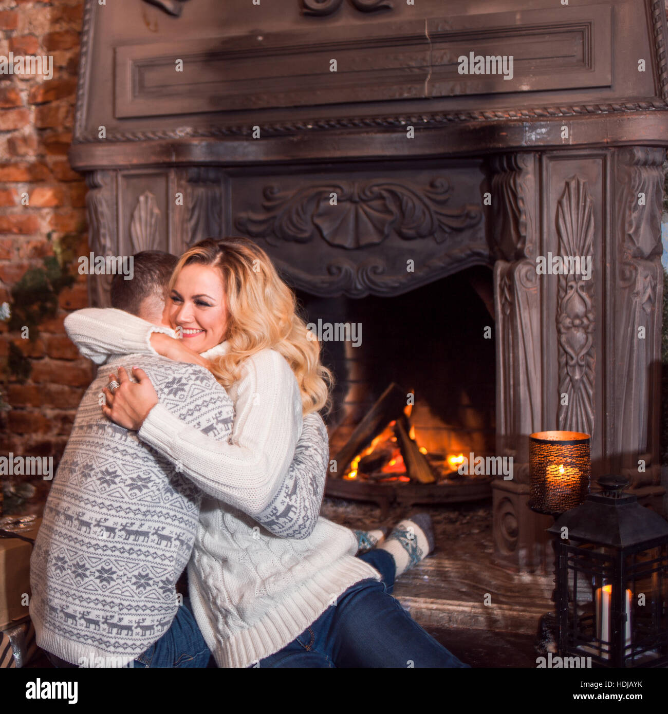 Man and a woman in warm knitted sweaters, hugging Stock Photo - Alamy
