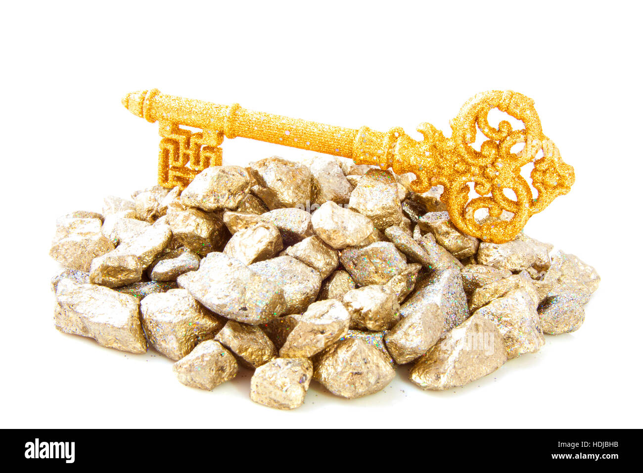Golden key on a pile golden stones isolated over white Stock Photo - Alamy