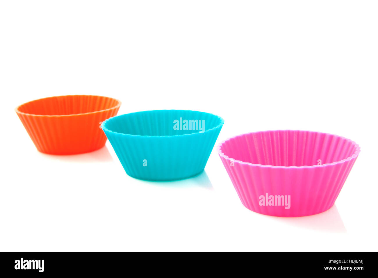 Three colorful cups in a row isolated over white Stock Photo - Alamy