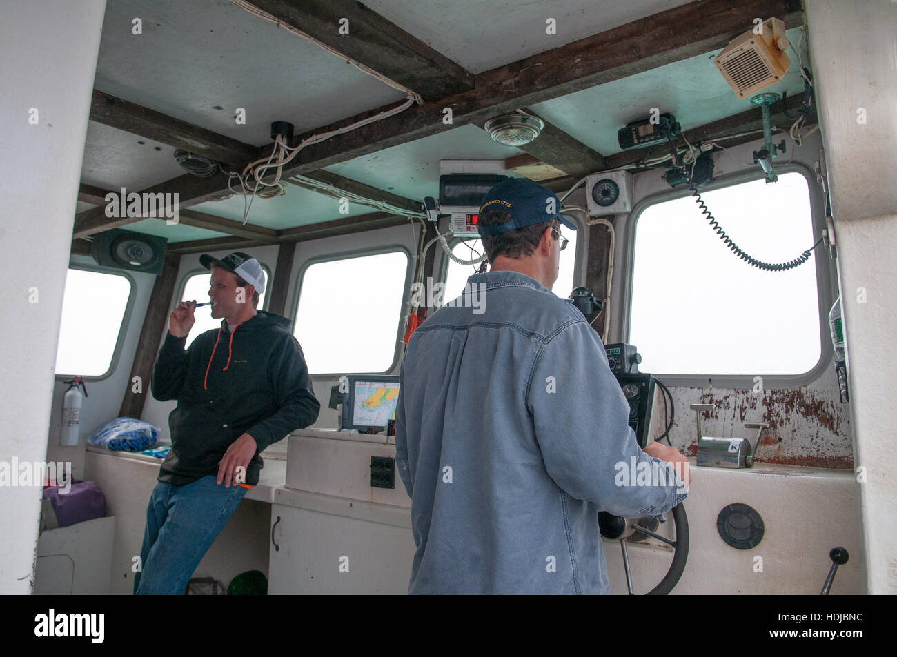 Lobster boat Captain and sternman head out to check their pots ...