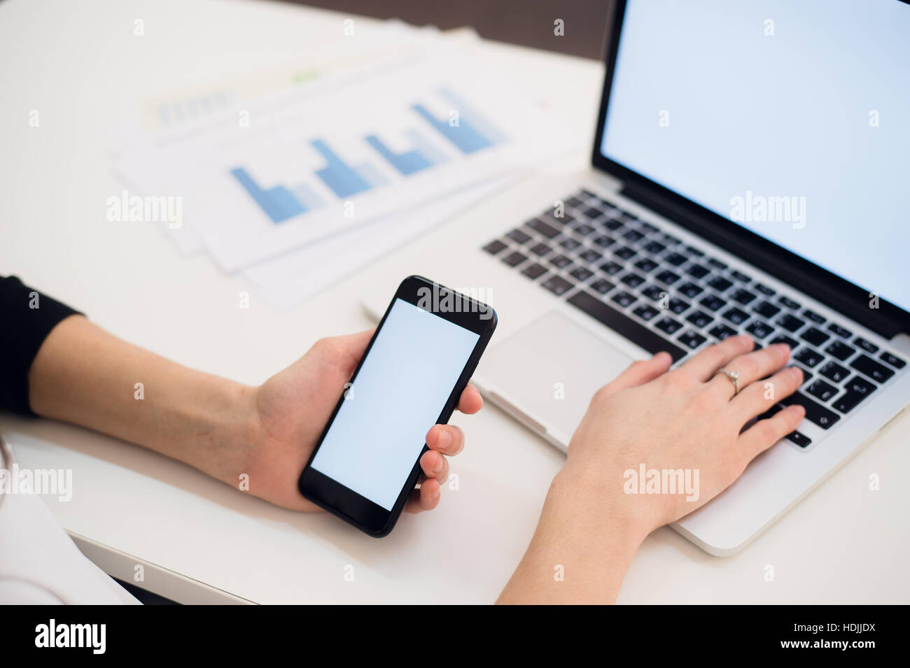 Close Up of woman hands using mobile phone and laptop computer with ...