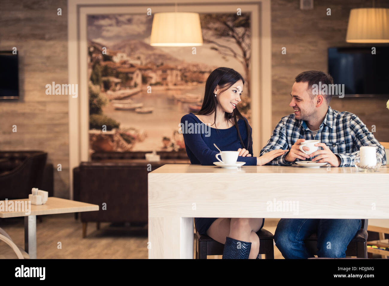 Young couple talking in coffee shop Stock Photo - Alamy