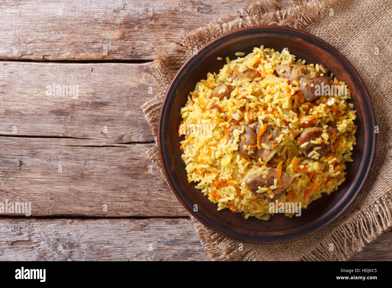 Delicious Asian pilaf on a brown plate. horizontal view from above ...