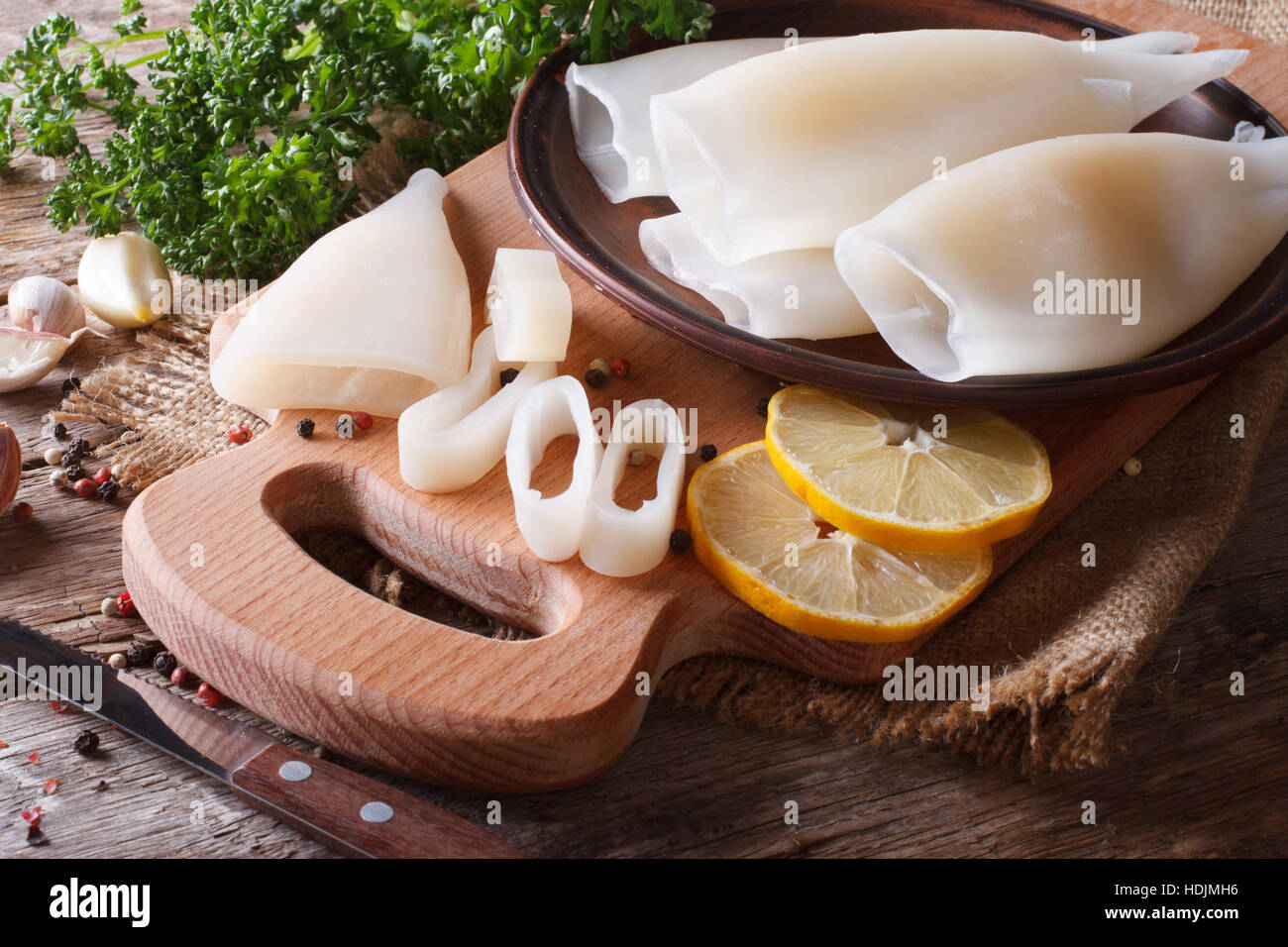 Sliced raw squid with ingredients on the kitchen board closeup ...