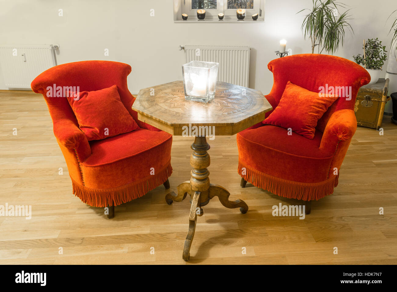 Candles on a antique side table with intarsia and red chair Stock Photo ...