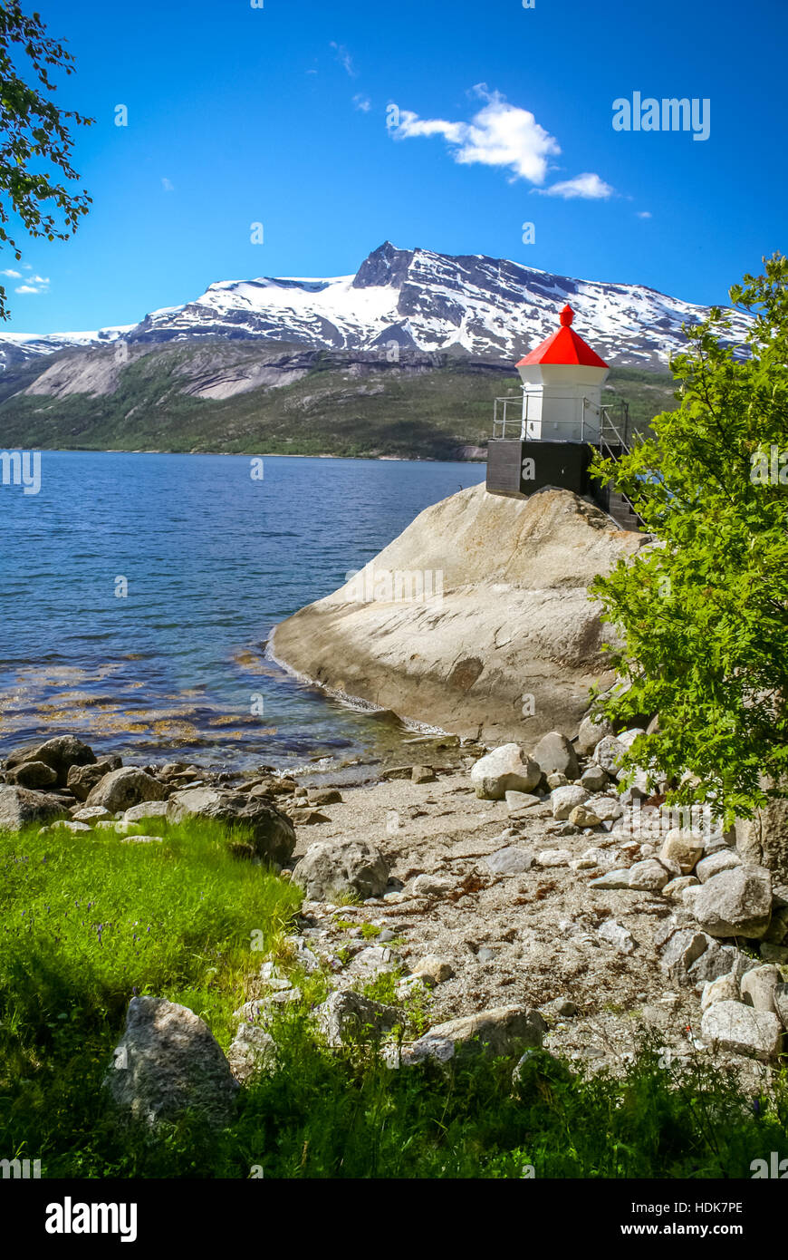 Photo of countryside with small lighthouse on large rock on bank of ...