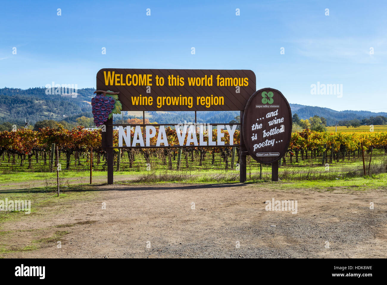 view of the napa valley welcome sign with color changing grape vines in ...