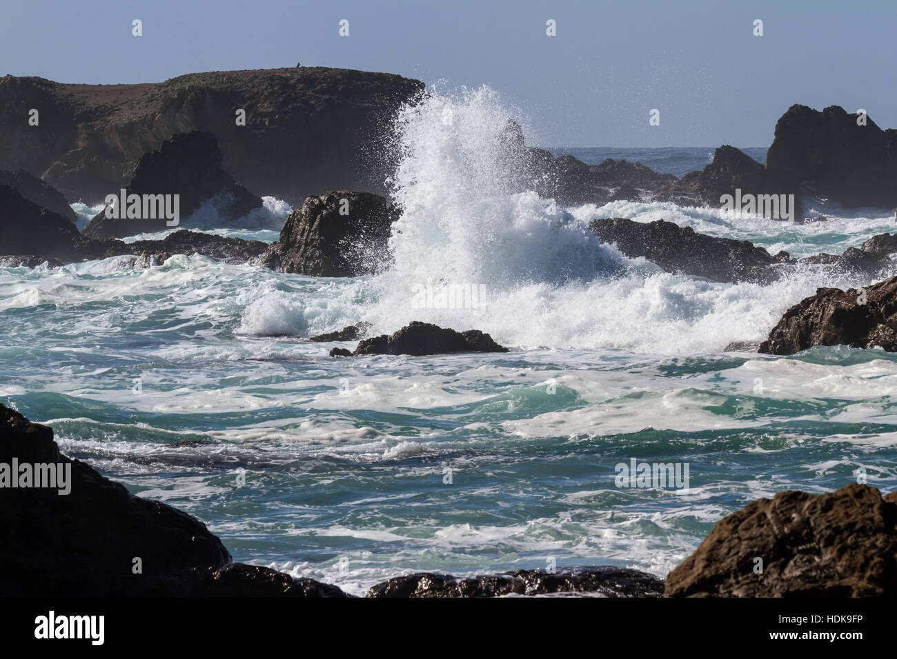 powerful waves crashing against large rocks as the tide comes in and ...