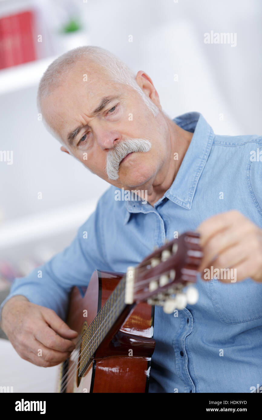 an elderly man playing an acoustic guitar Stock Photo - Alamy