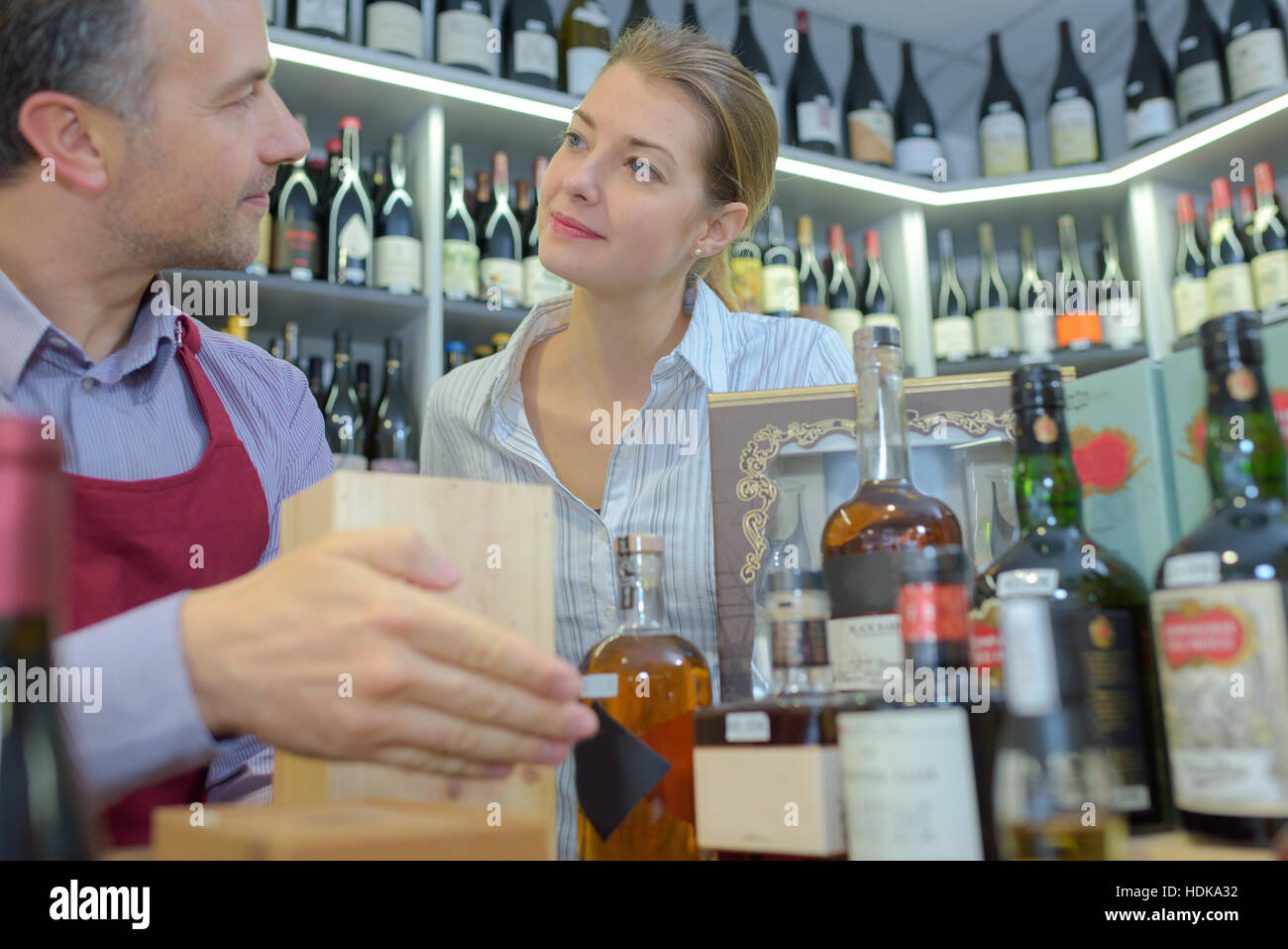Sales assistant with customer in liquor store Stock Photo - Alamy