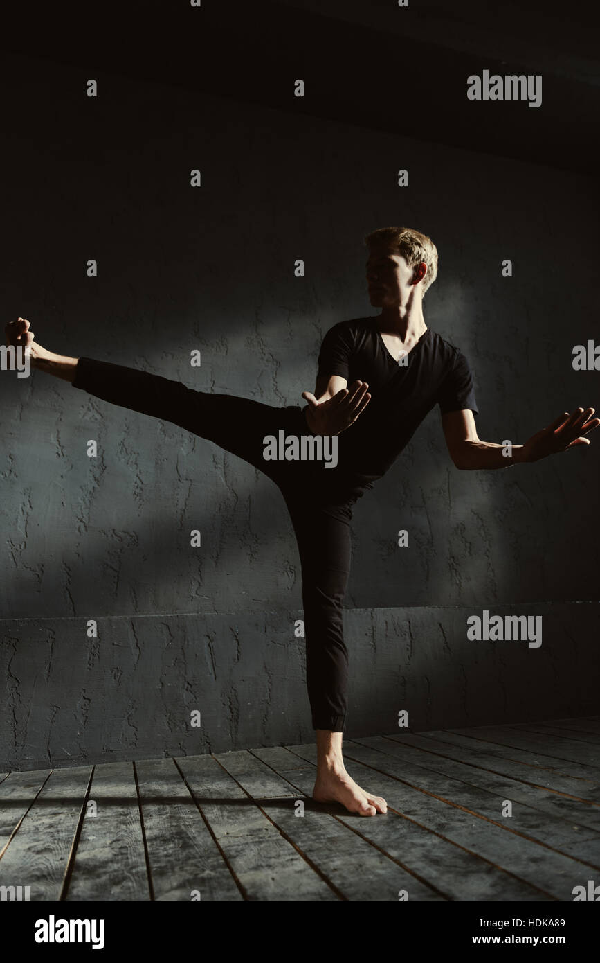 Skillful young man performing in the dark lighted room Stock Photo - Alamy