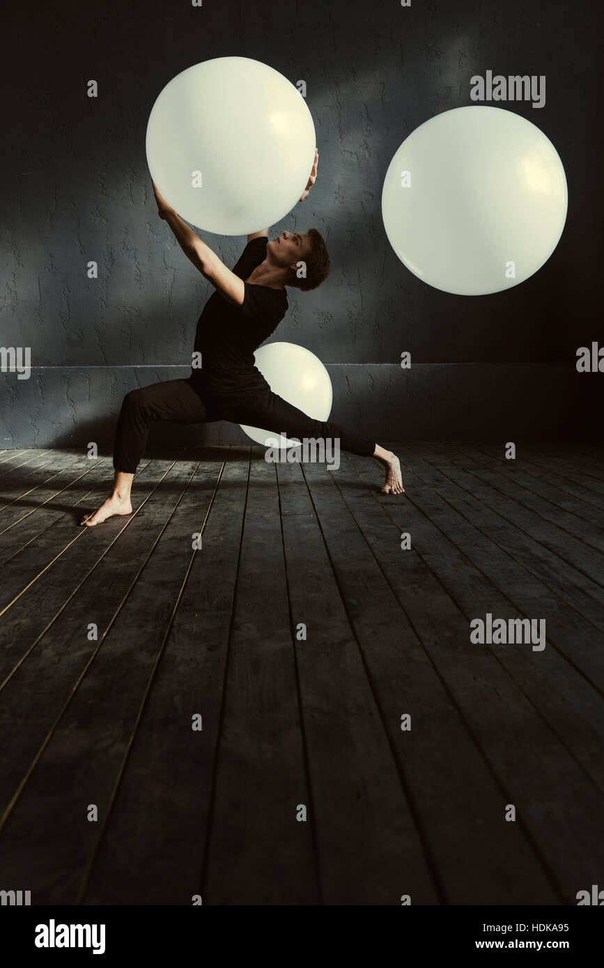 Flexible man dancing in the dark lighted studio Stock Photo - Alamy