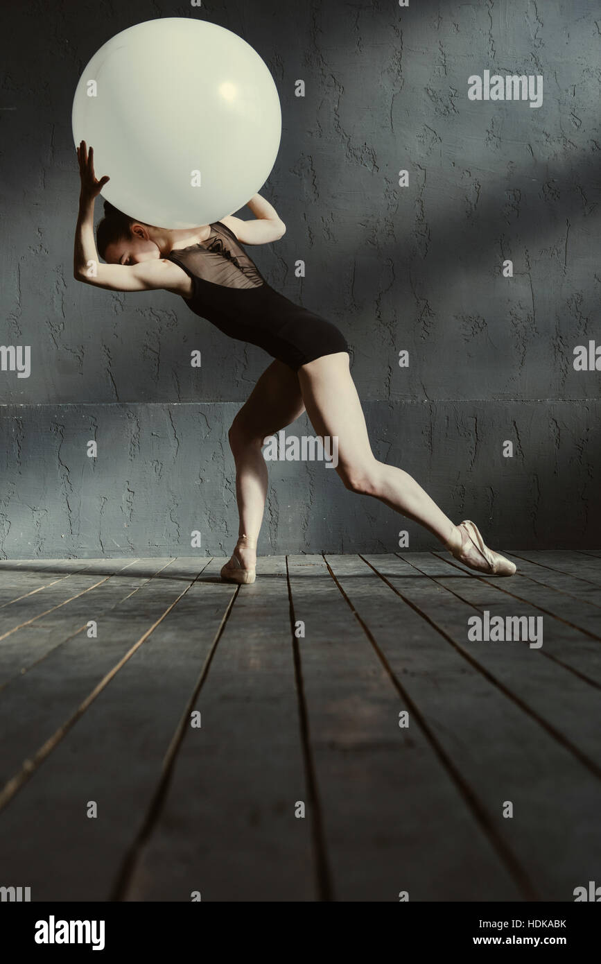 Trained gymnast performing using the white ball Stock Photo - Alamy