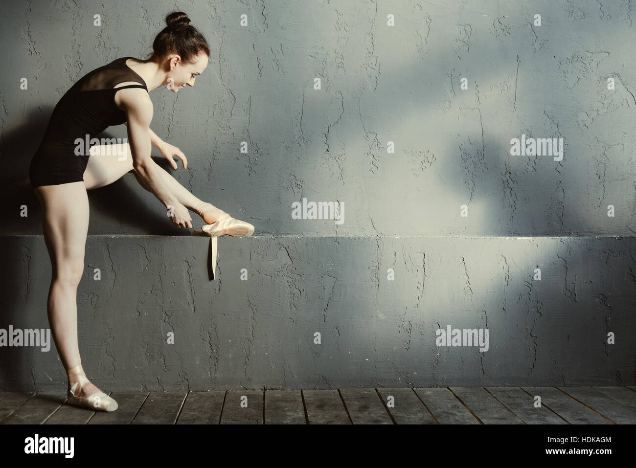 Positive ballet dancer wearing her points in the dancing saloon Stock ...
