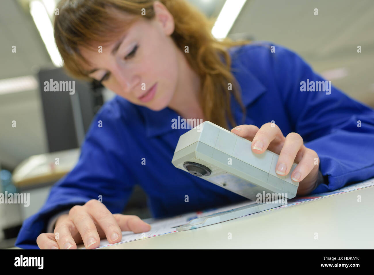 Lady using hand held machine Stock Photo - Alamy