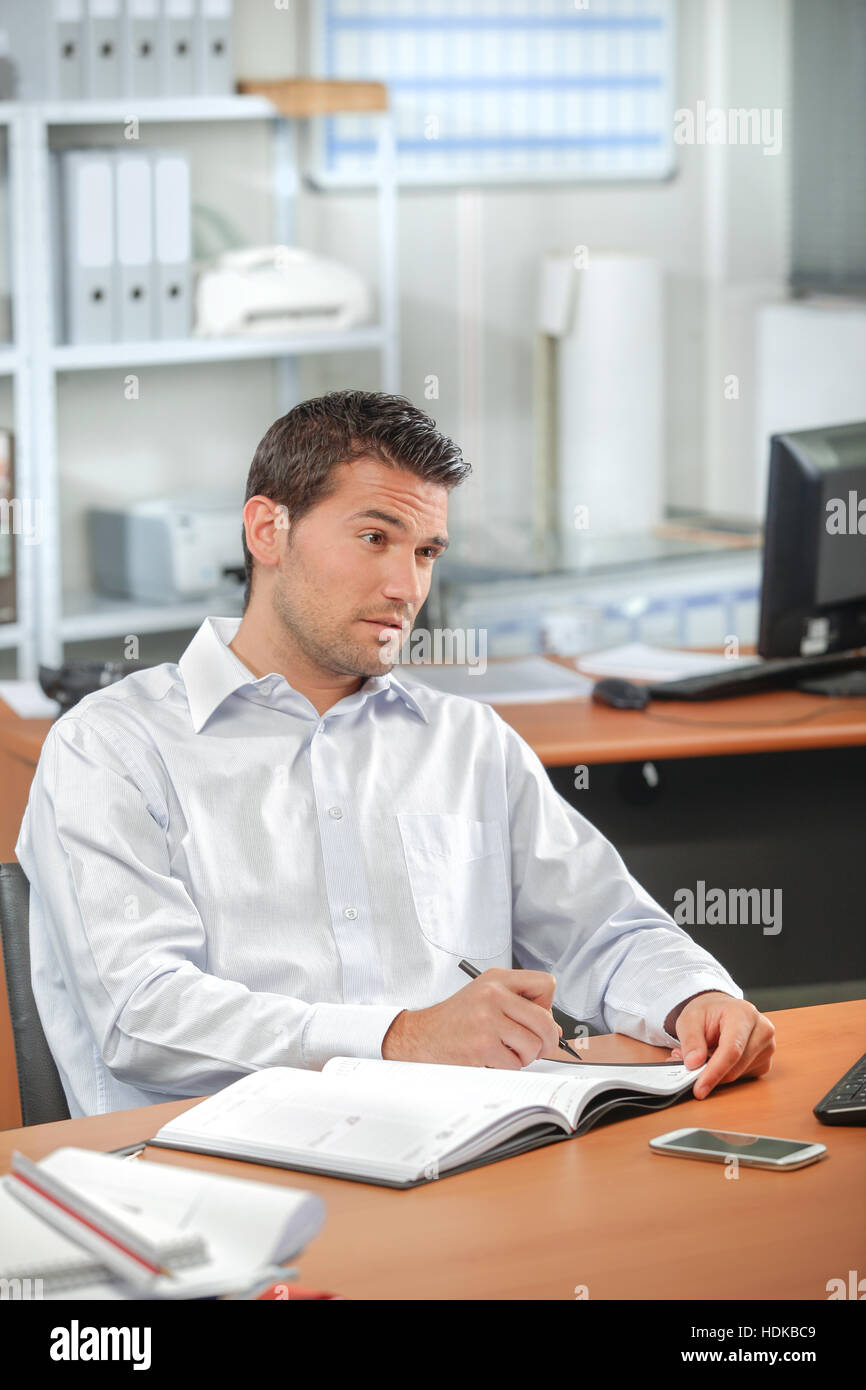 Man sat writing at his desk Stock Photo - Alamy