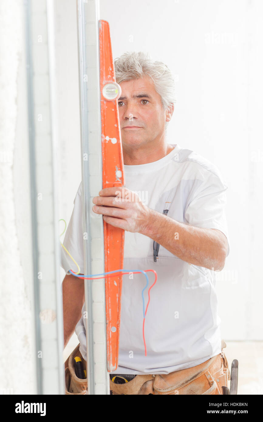 Builder using spirit level Stock Photo - Alamy