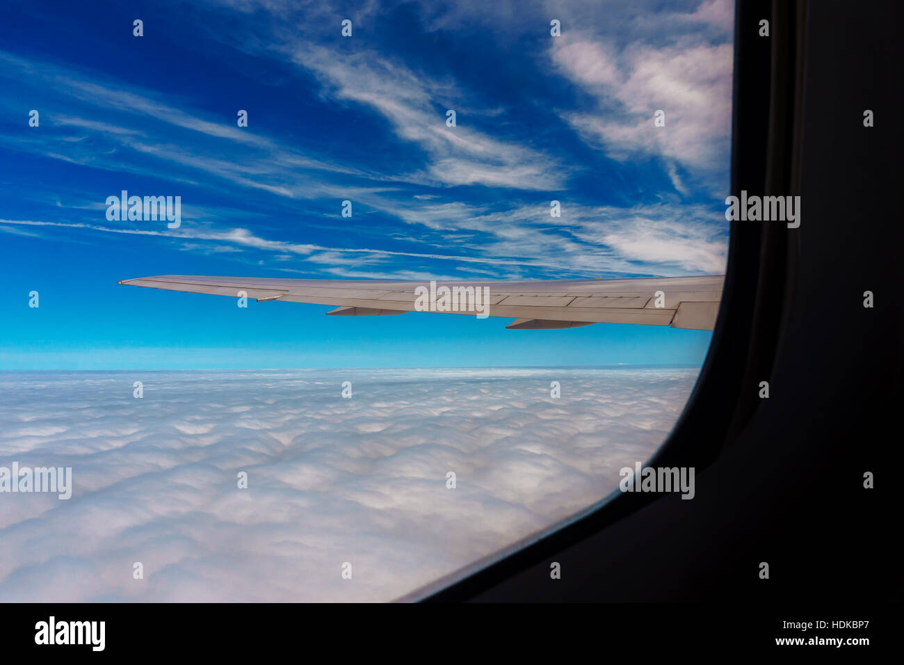 Clouds and sky and Airplane Wing as seen through window of an aircraft ...