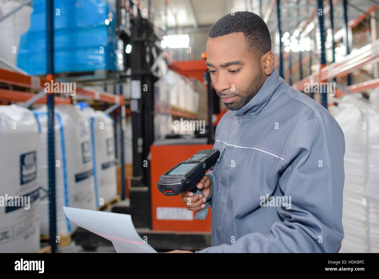 Warehouse worker using handheld scanner Stock Photo - Alamy