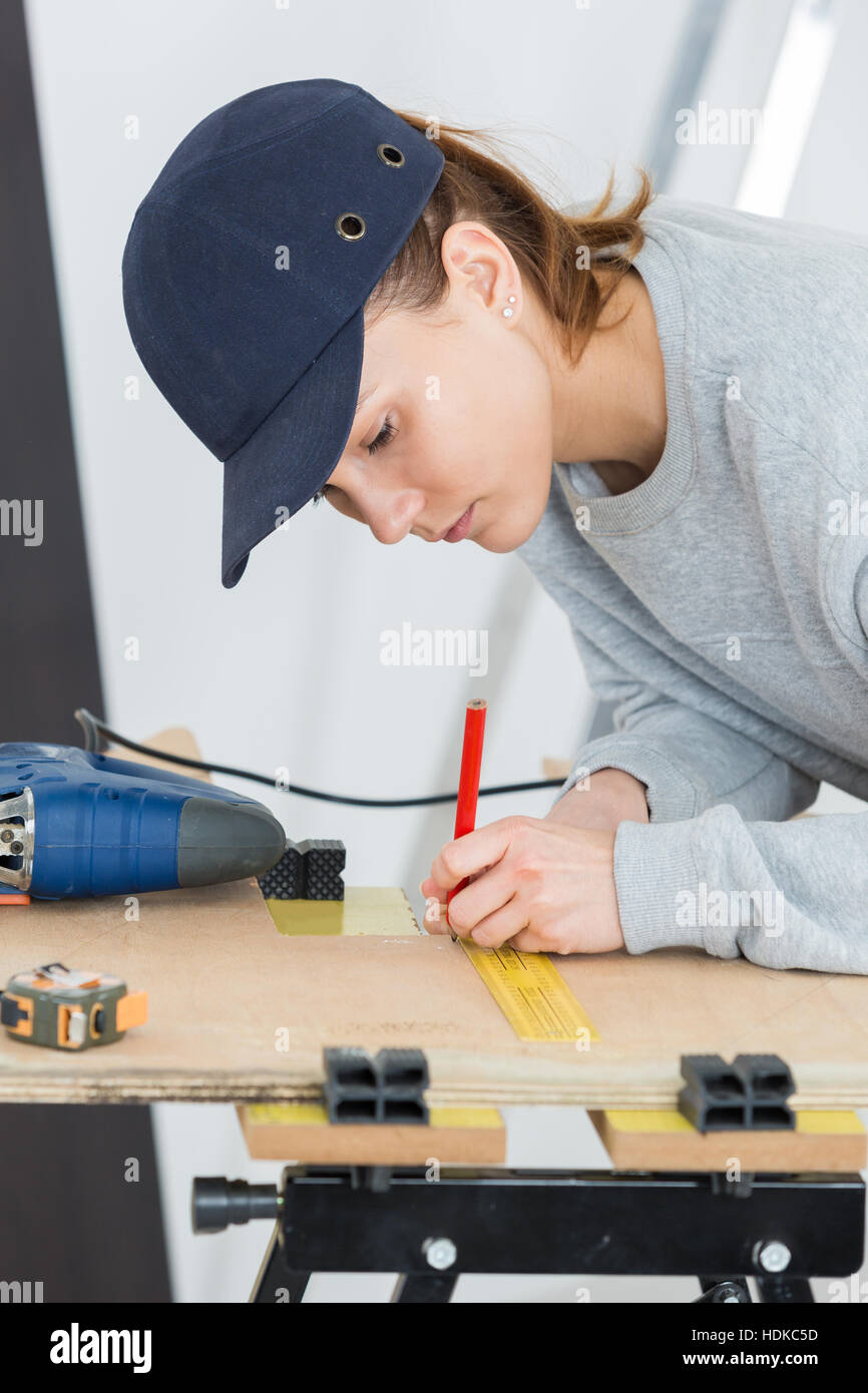 Female carpenter marking position on wood Stock Photo - Alamy