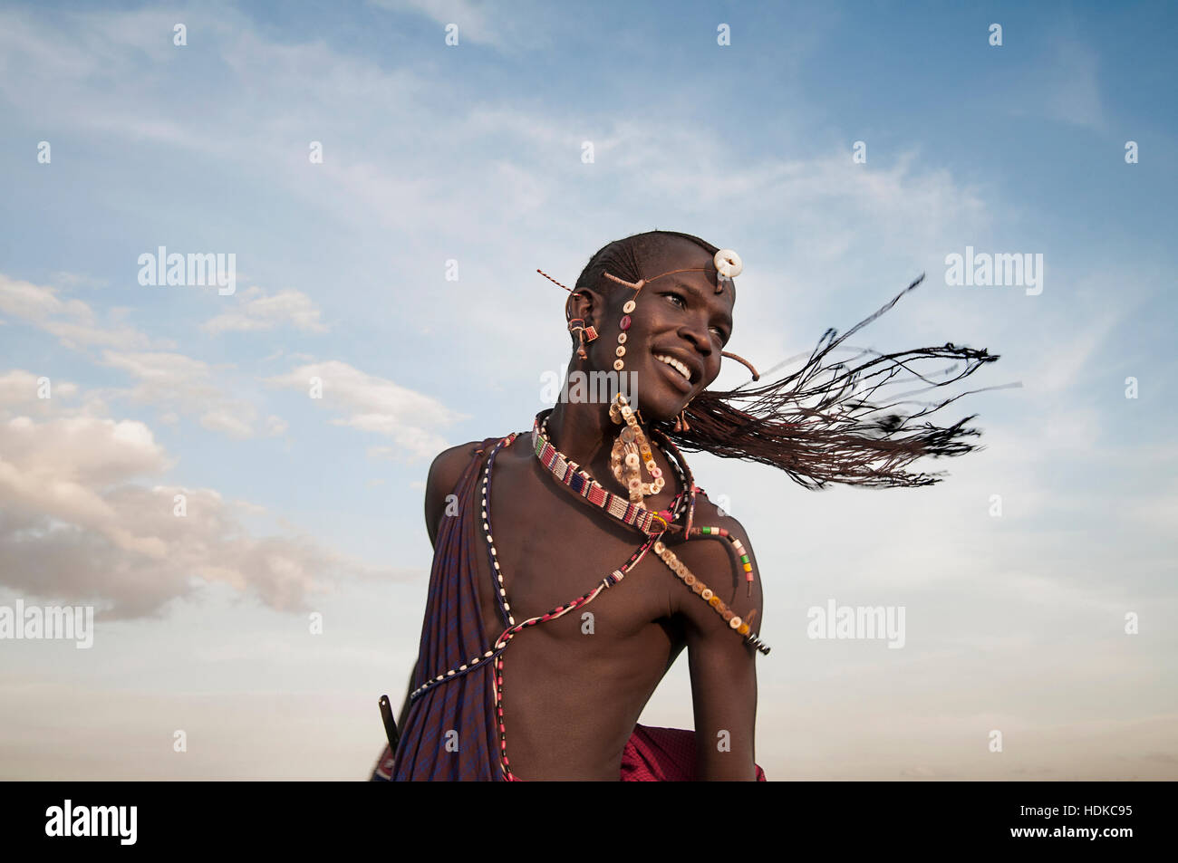 Happy Maasai Warrior Portrait with Braids Flying Against the Sky Stock ...