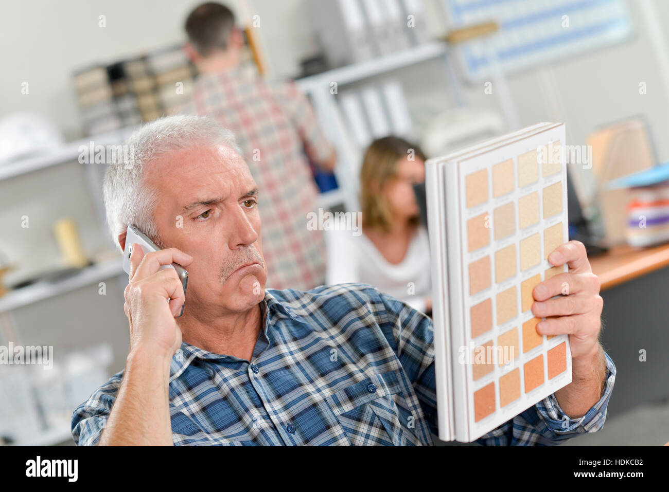Man on telephone with skeptical expression, holding color charts Stock ...