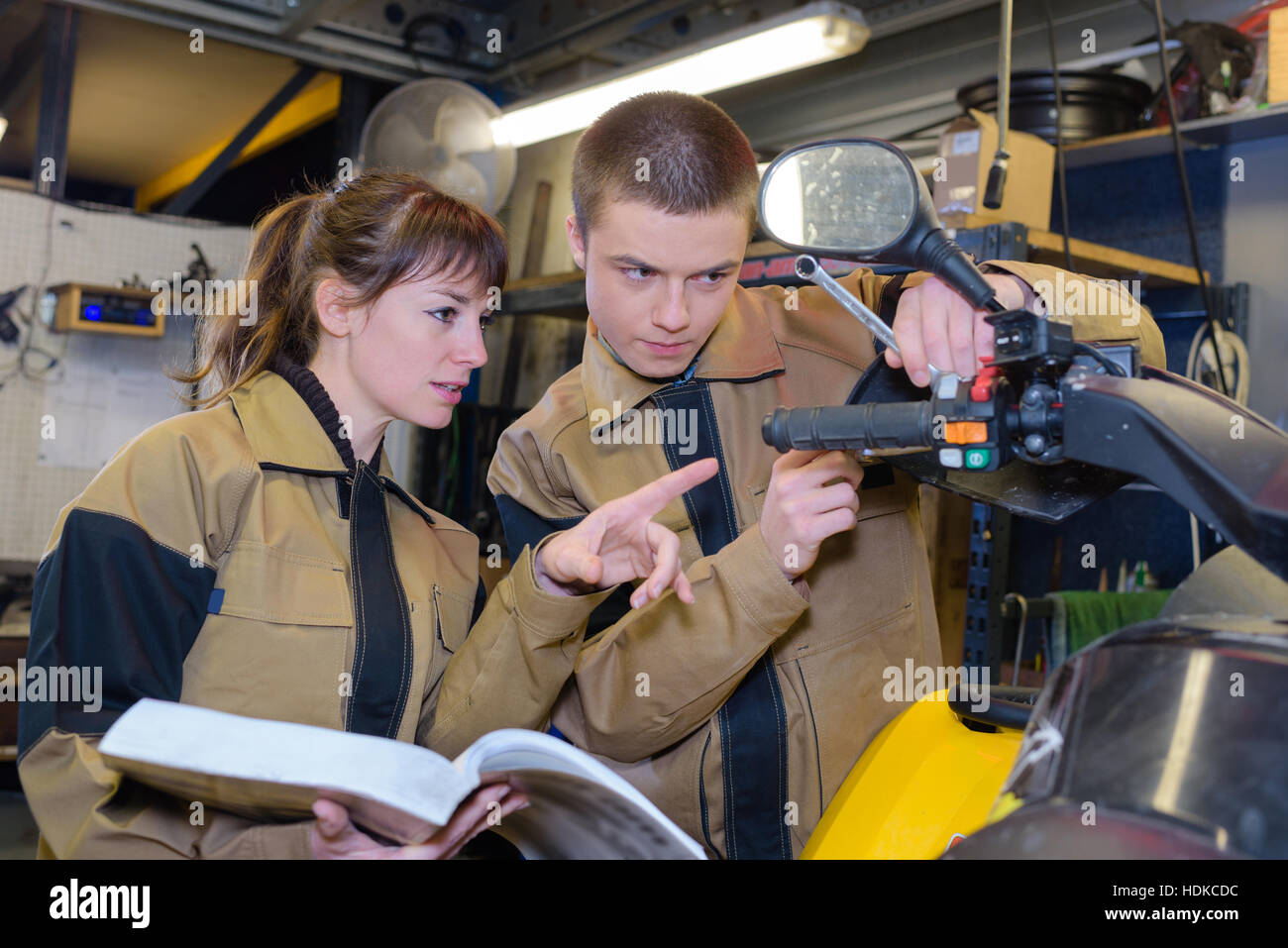 Mechanics working on handlebars of scooter Stock Photo - Alamy