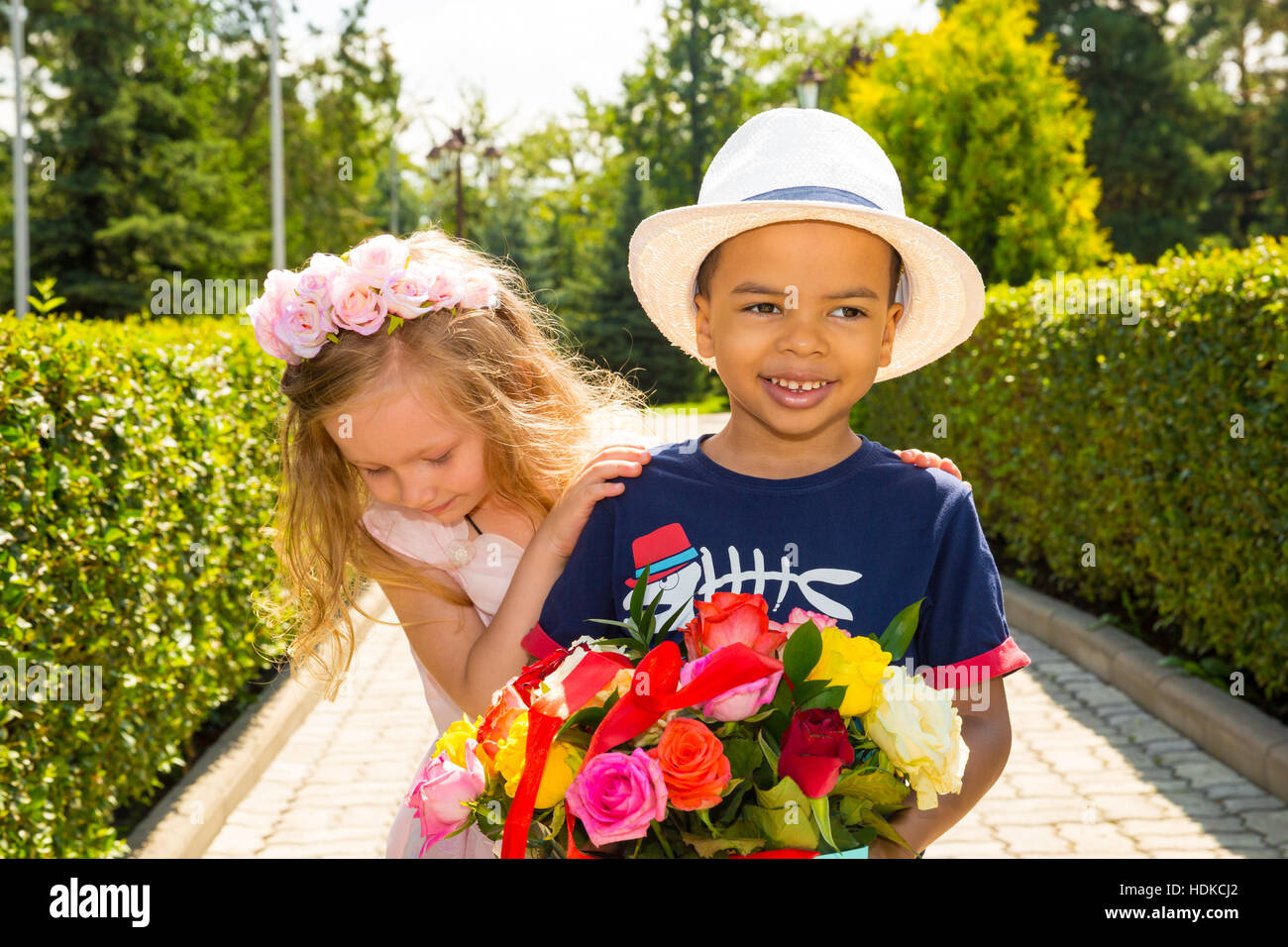 Black african american boy kid gives flowers to girl child on birthday ...