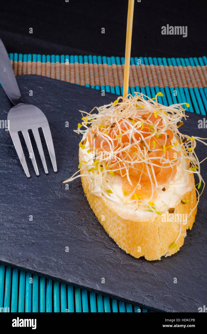 Pincho style salmon tapa served on goat cheese Stock Photo - Alamy