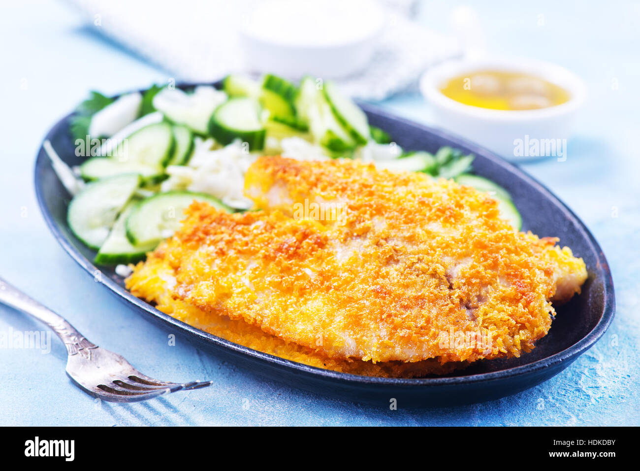 fried fish on plate and on a table Stock Photo - Alamy