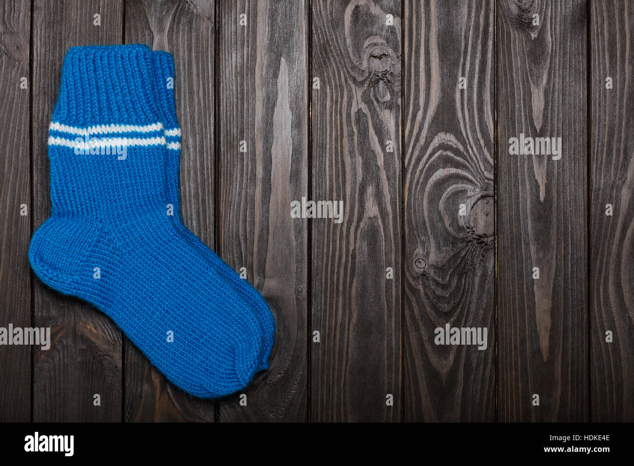 Knit blue wool socks on dark wooden background Stock Photo - Alamy